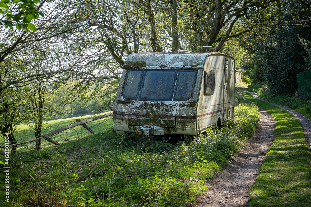 Abandoned touring caravan on the roadside verge of a farm track ...