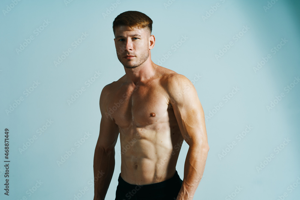 bodybuilder with muscular body posing press blue background Stock Photo ...
