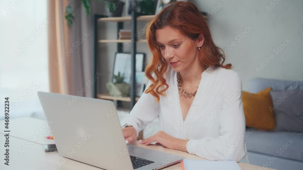 Successful young Caucasian woman slowly typing text into laptop and ...