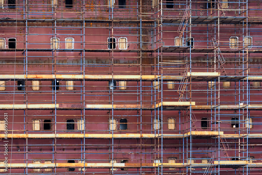 Scaffolding on the metal wall. Construction of a ship. Scaffolding on ...