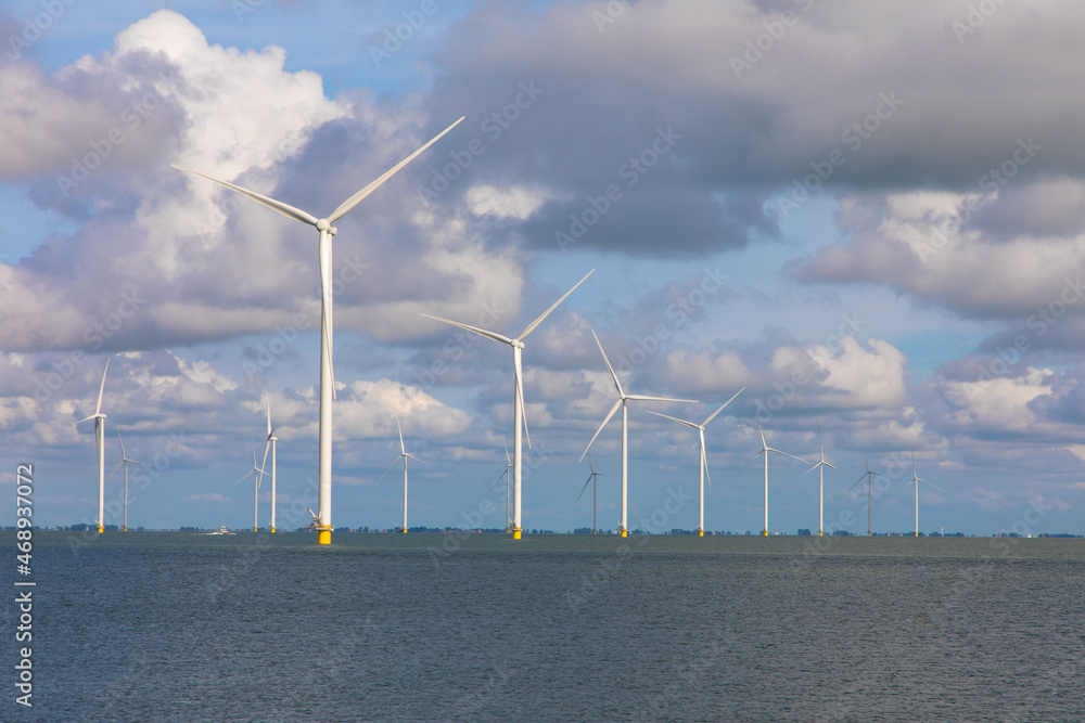 Aerial view of enormous windmills stand in the sea along a dutch sea ...