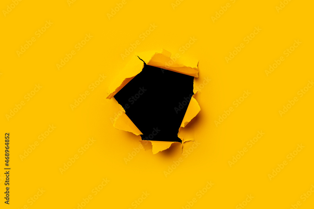 Bright yellow torn paper inside a black hole in a hole. Stock Photo ...