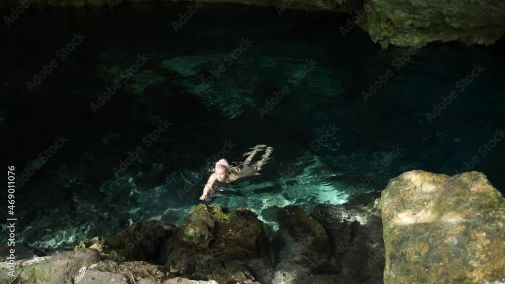 Young blonde woman swimming in a Cenote in Tulum. Turquoise pool in ...
