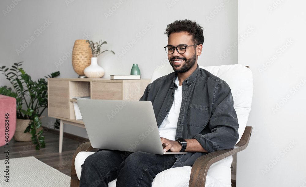 Young man using laptop computer at home. Student men working or ...