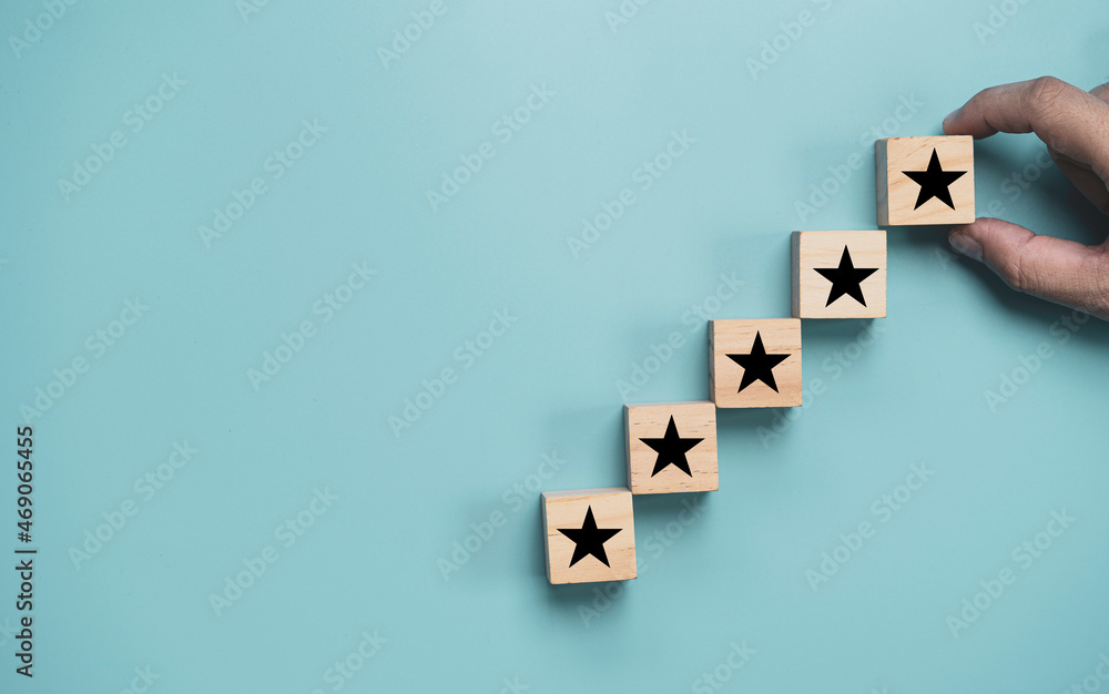 Hand stacking for five stars increasing on blue background for client ...