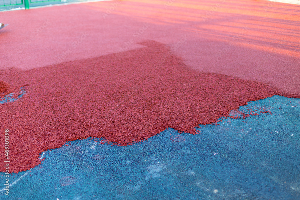 red rubber covering for the playground, the master smoothes the soft ...