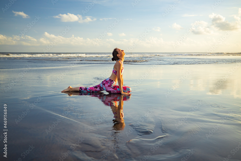 Yoga on the beach. Slim woman practicing Ardha Kapotasana, Half Pigeon ...