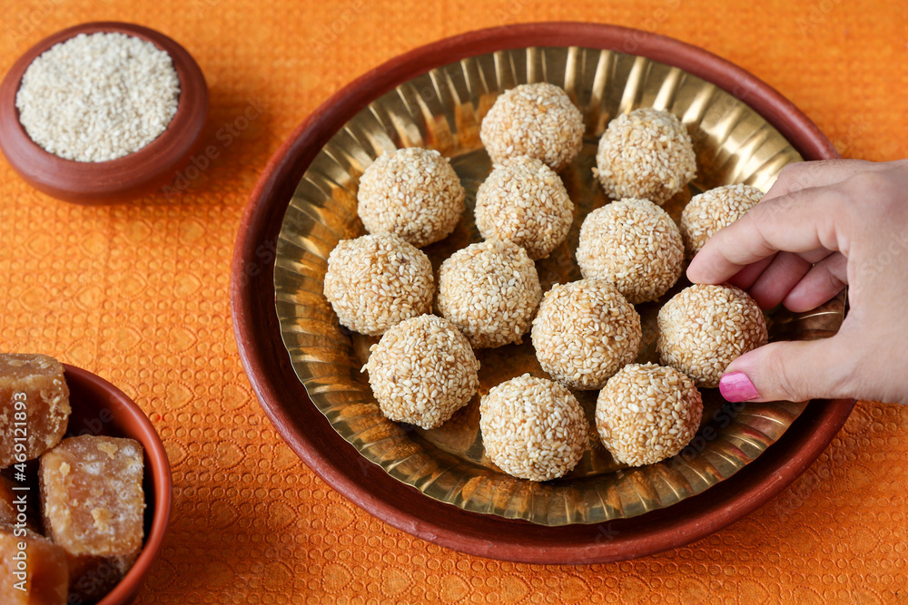 Til ladoo laddu woman hand take white sesame ladoo ellu urundai Indian ...