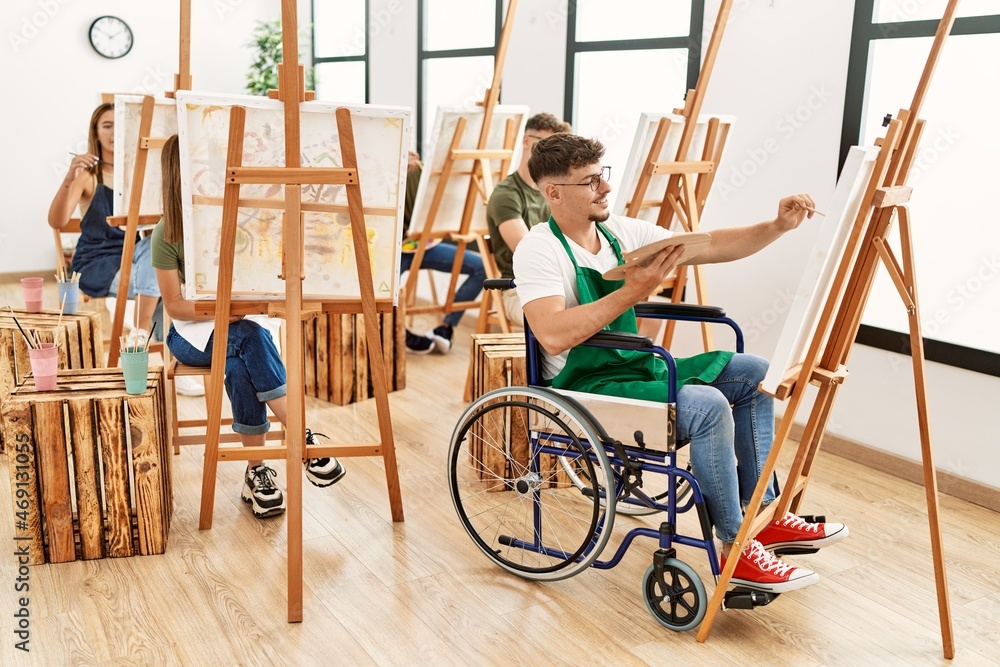 Group of people drawing at art studio. Young man sitting on wheelchair ...