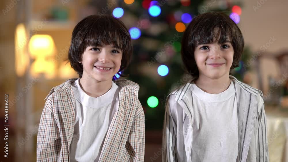 Two happy Middle Eastern twin brothers looking at camera smiling with ...