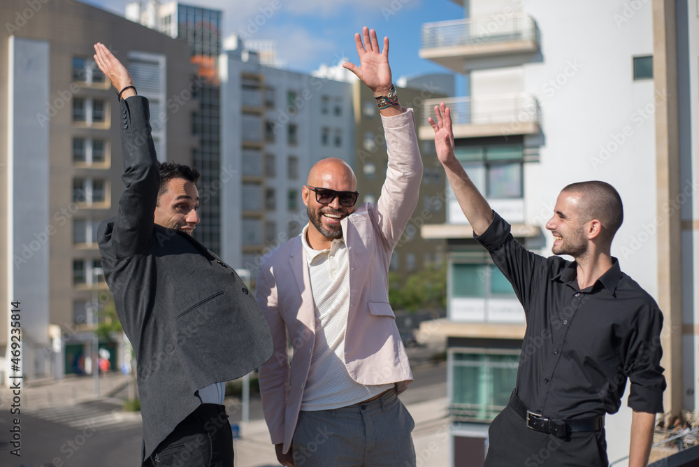 Happy businessmen putting their hands in air. Smart-dressed men during ...