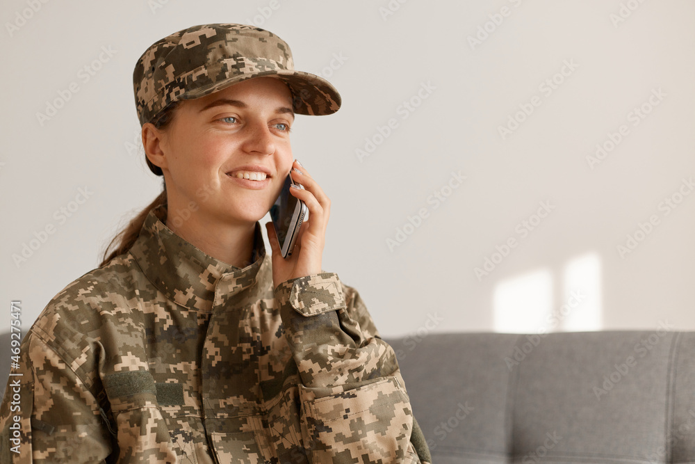 Smiling positive female soldier wearing military costume, posing indoor ...