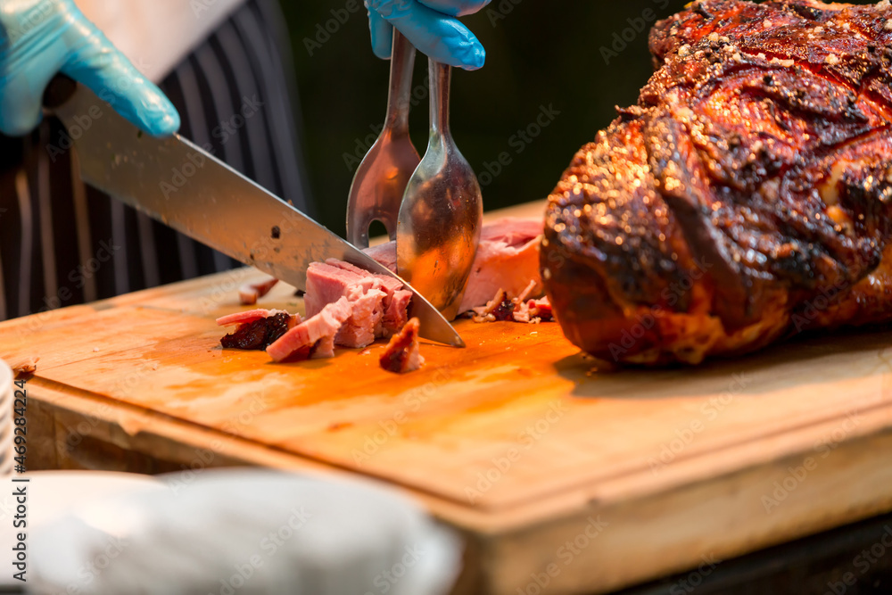 Grill restaurant kitchen. Chef in Blue cooking gloves using knife to ...