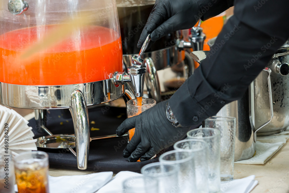 Foto de A glass is filling juice from juice tank. glass for water ...