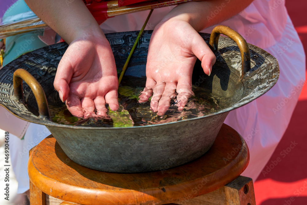 People wash their hands in the bronze basin at the ceremony to worship ...