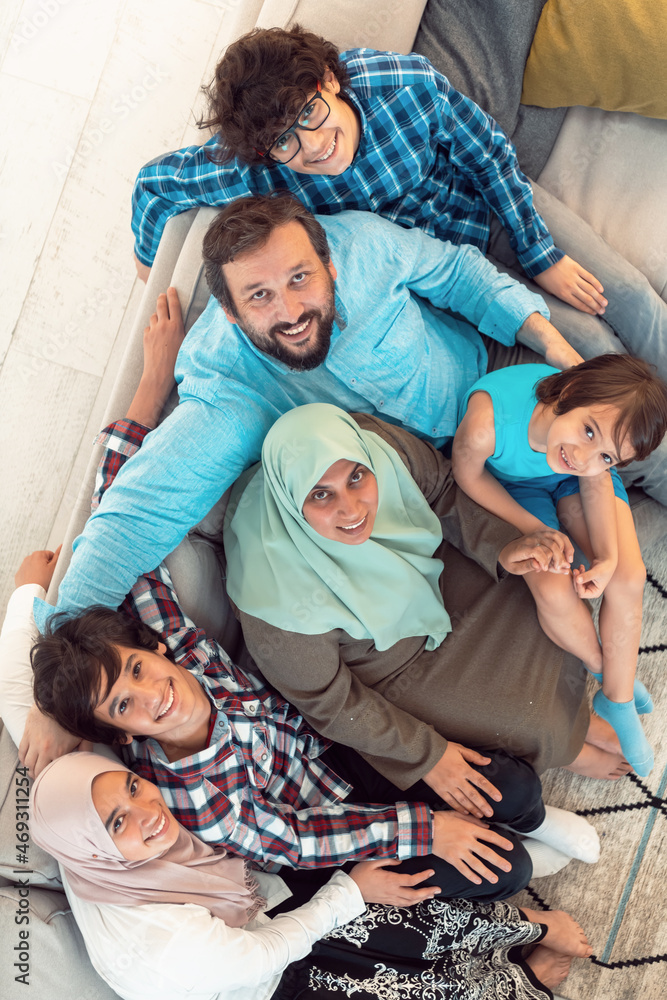 Top view photo of an Arab family sitting in the living room of a large ...