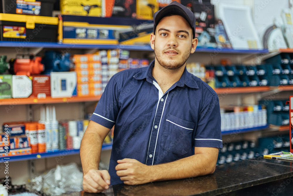 Young latin man working in hardware store Stock Photo | Adobe Stock