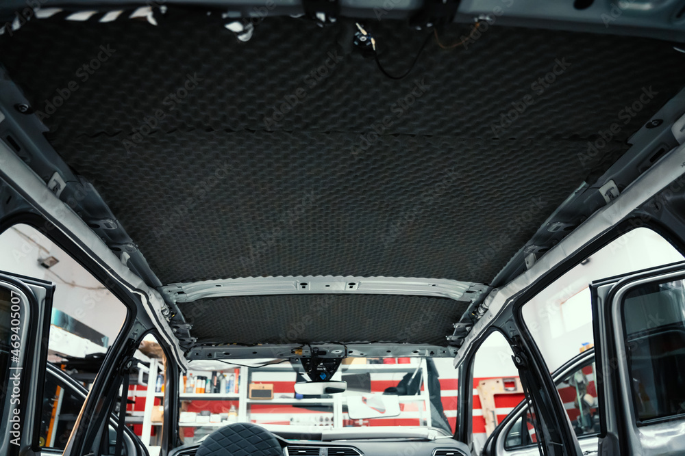 Car in process of installing sound insulation. Roof of car is covered ...