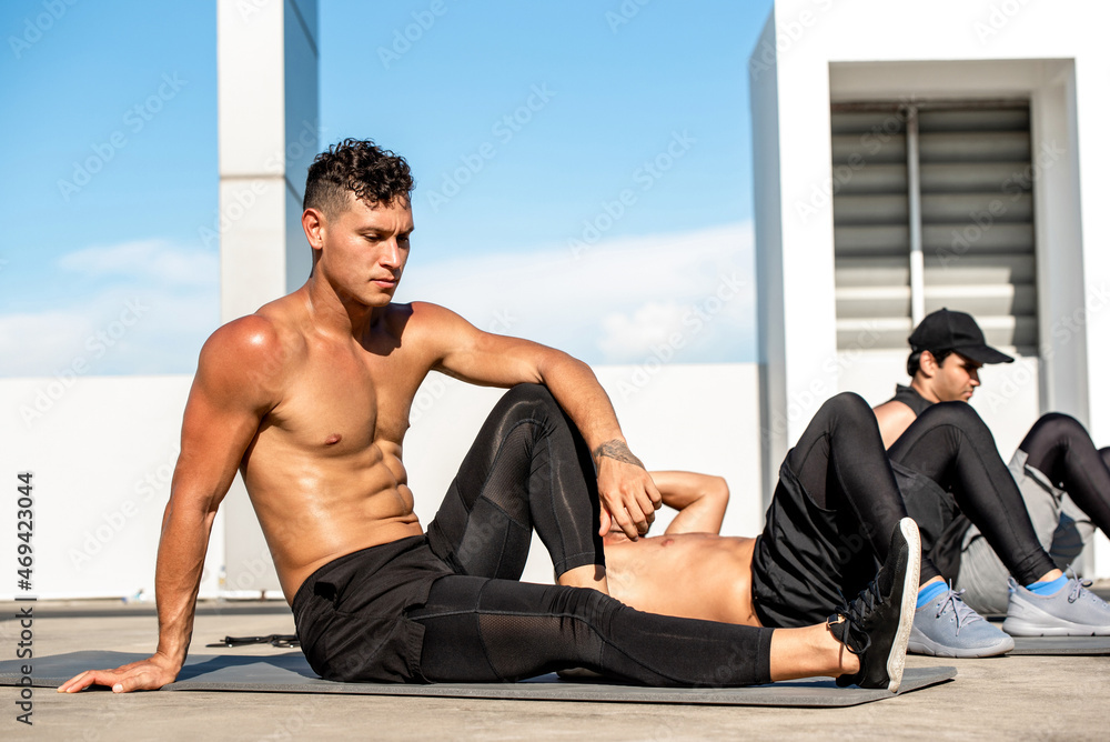 Diversity fit male bodybuilder group doing bodyweight exercise outdoors ...