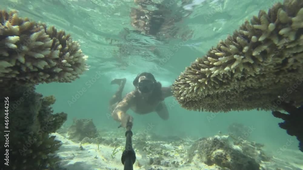 A young, fit and strong man with long hair and beard is swimming in ...