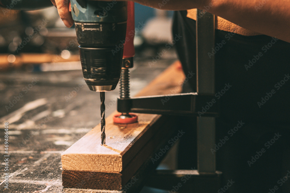 Drilling a hole with a drill and a drill bit in a wooden Stock Photo ...