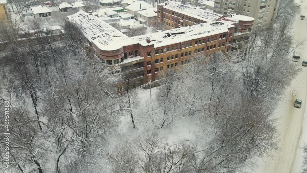 An old house with a destroyed roof covered with snow after a blizzard ...