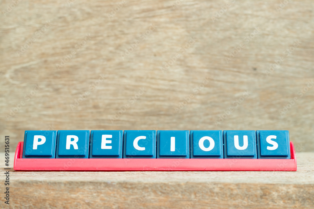 Tile alphabet letter with word precious in red color rack on wood ...