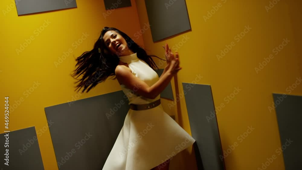 Beautiful girl dressed in white dress dancing moving smiling inside ...