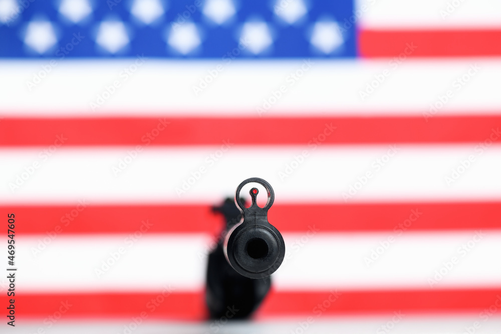 Weapons and American flag background. Close up of muzzle and sight of a ...