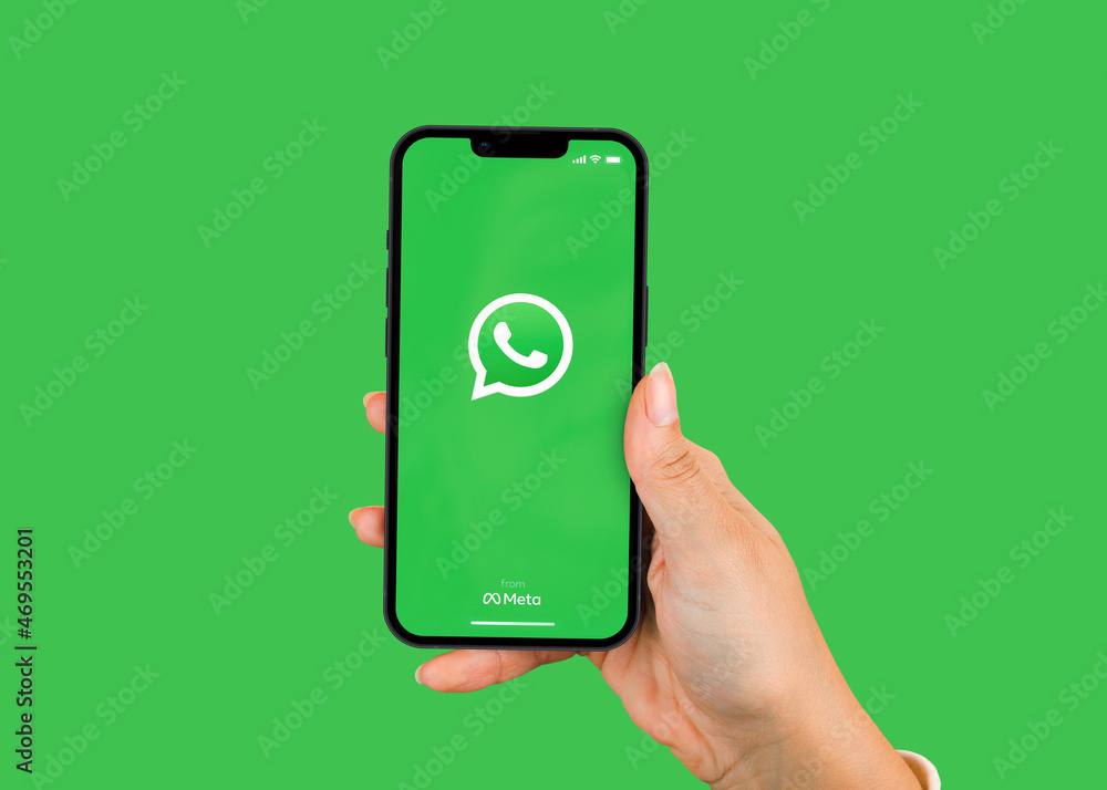 Female hand holding a smartphone iPhone 13 Pro with Whatsapp app from ...