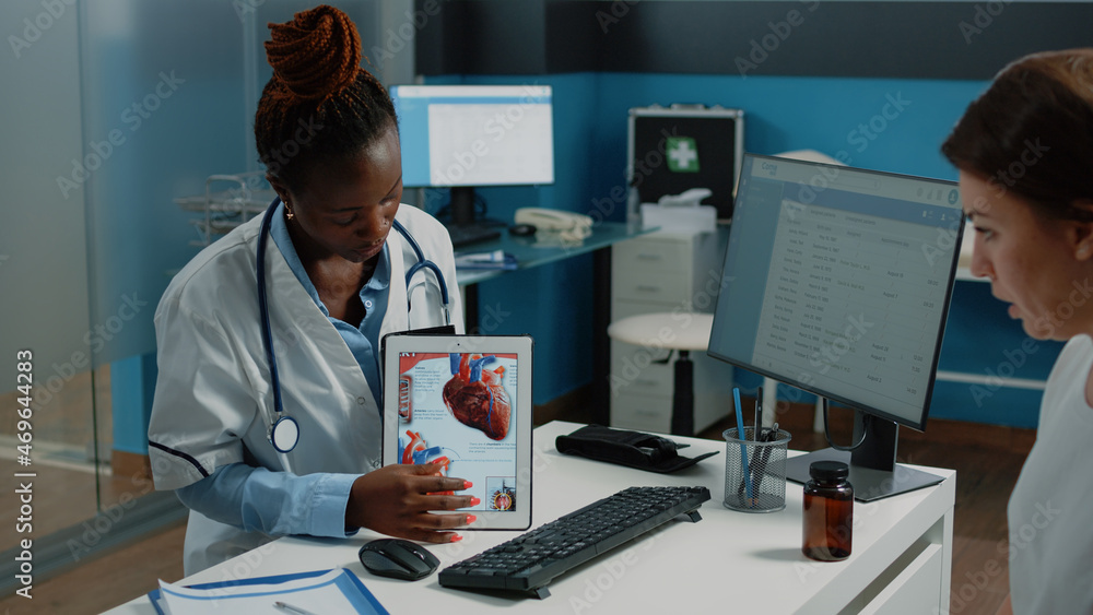 African american doctor showing cardiovasular image on tablet to ...