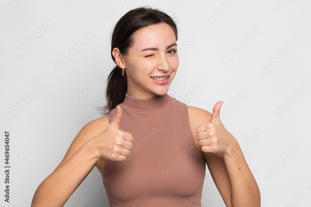 Portrait of playful and sweet young woman giving wink and showing ...