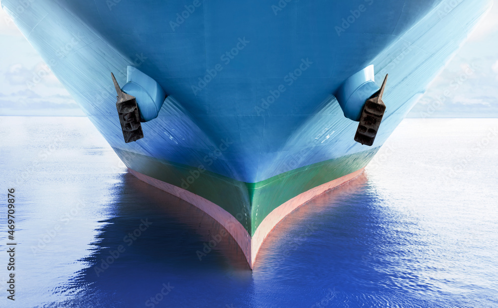 Front view of large blue merchant cargo ship in the middle of the ocean ...