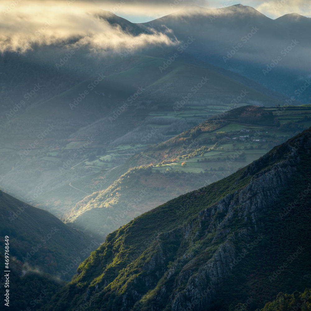 Tangential rays of the dawn sun illuminate villages and meadows between ...