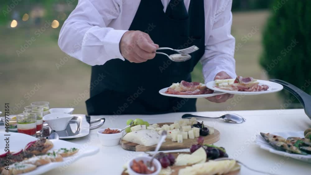 Restaurant waiter serving distinguished guests on official exit party ...
