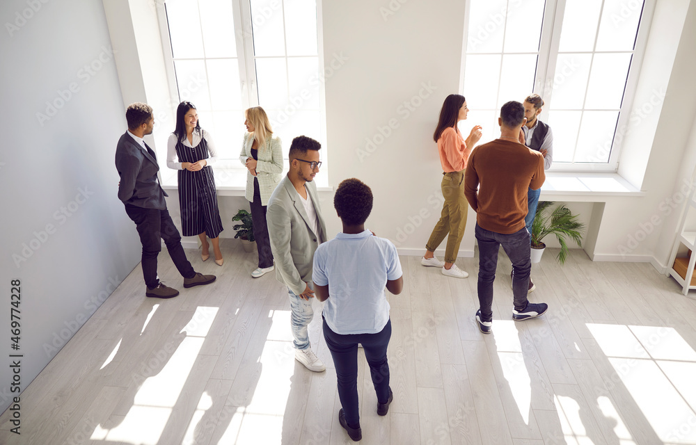 Diverse people talking in groups during a meeting. High angle shot of ...