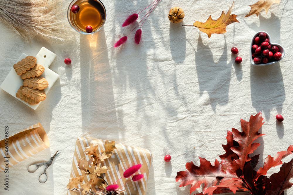Autumn decorations - cranberry, cookies. tea and dry oak leaves. Flat ...
