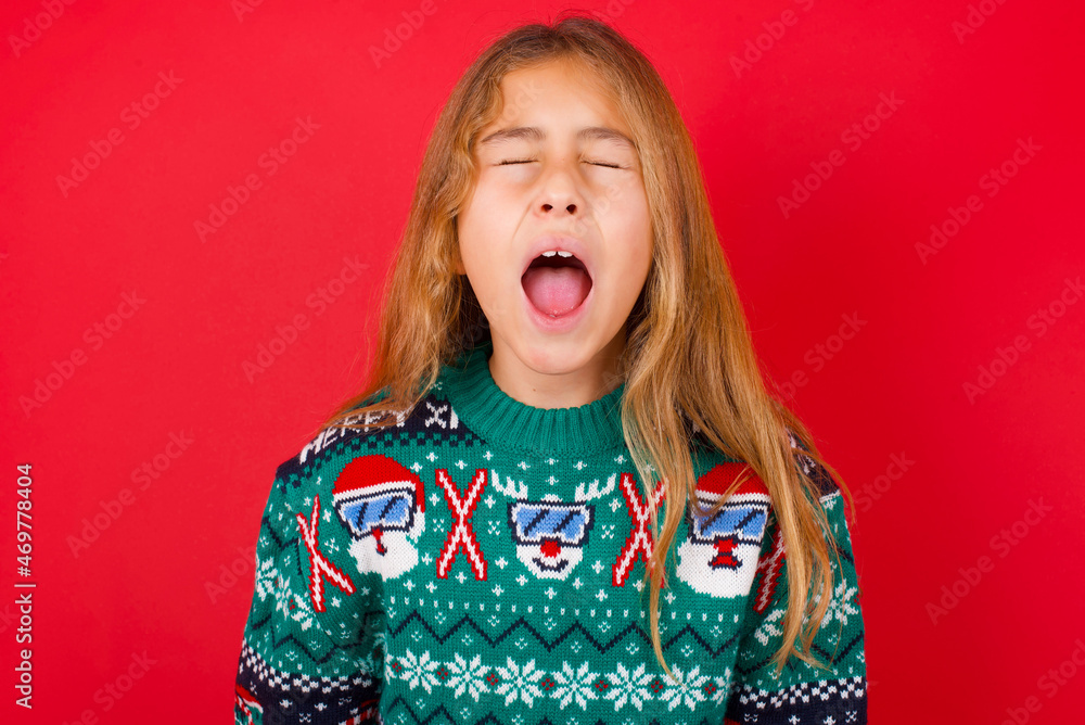 Stressful little kid girl wearing knitted sweater christmas over red ...