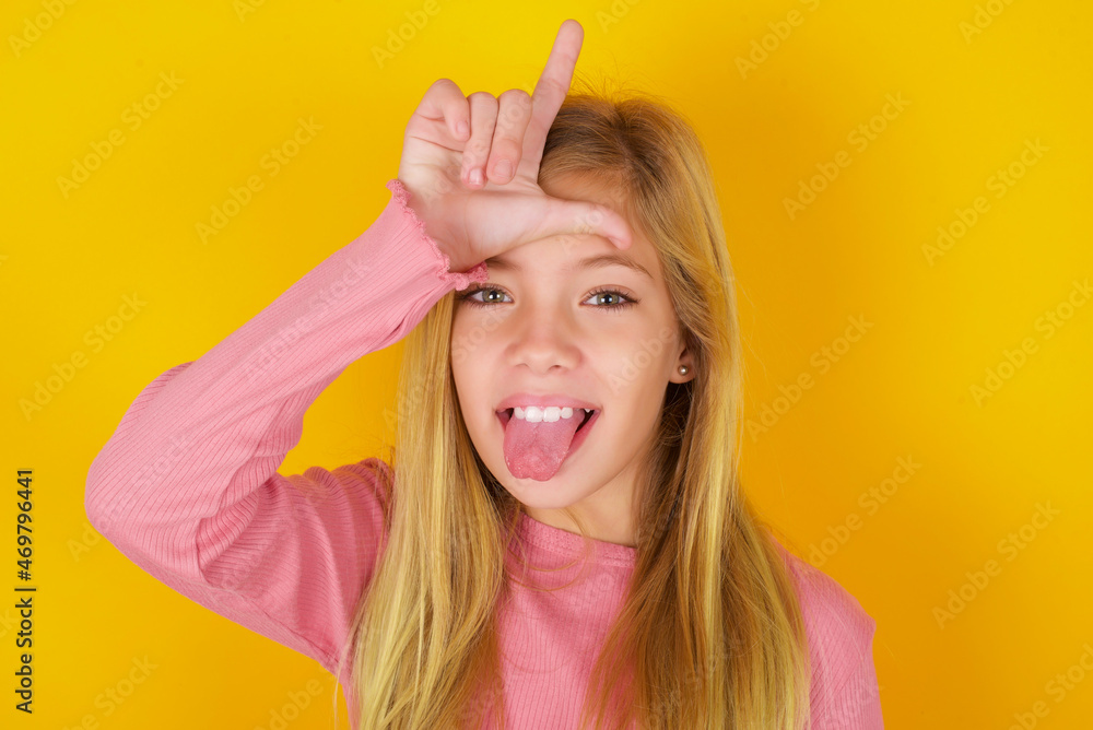 Funny caucasian little kid girl wearing long sleeve shirt over yellow ...