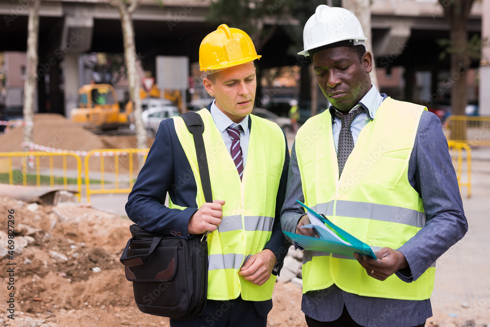 Two workers working at the laying paving slabs facility are carefully ...