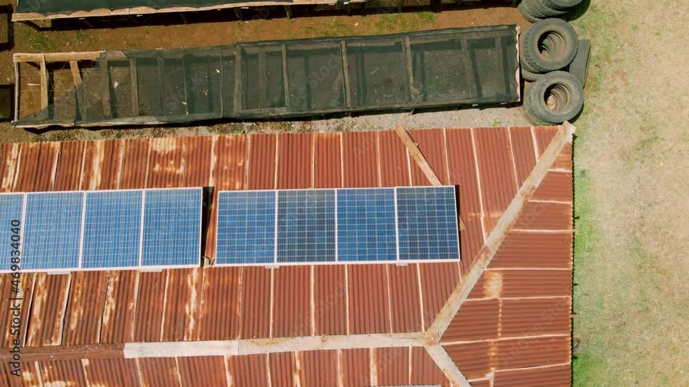 Solar on rusted rooftop in rural Africa powered by solar. 4K Aerial ...