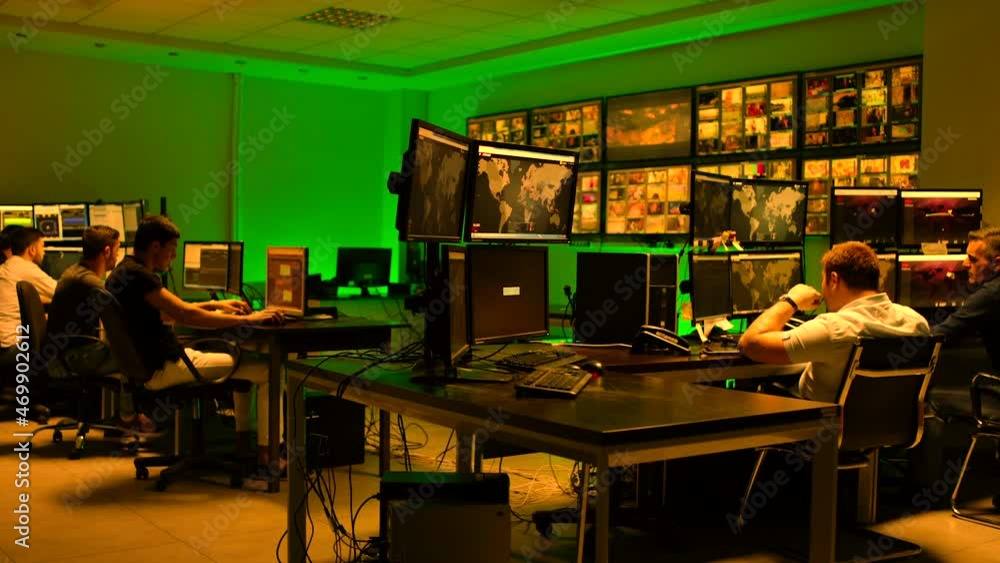 Male workers sitting near computers on monitoring room and working ...