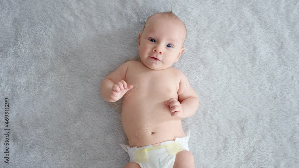 A healthy newborn baby in a nappy without clothes. Cute baby with blue ...