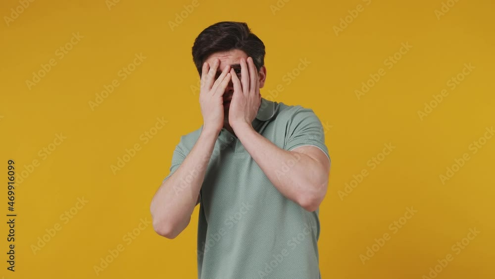 Scared shocked fun young man 20s years old wear green polo shirt look ...