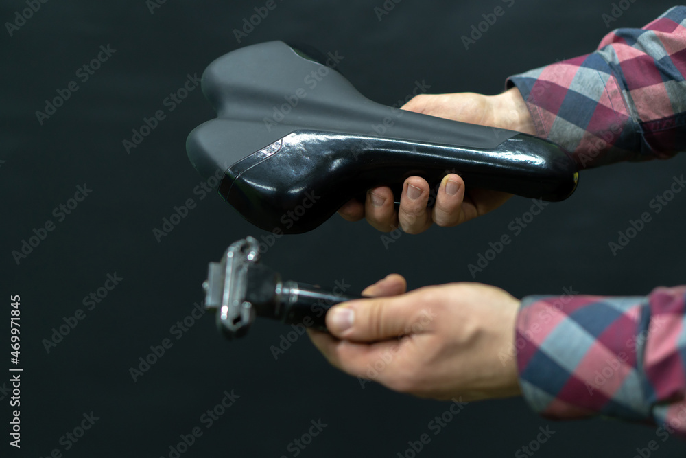 A mechanic in a bicycle workshop repairs mountain and road bikes. The ...