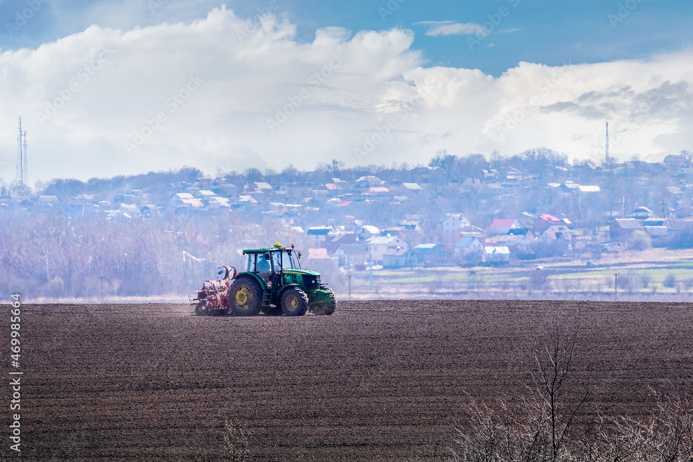 Ukraine, Khmelnytsky region, March 2021. Tractor with a seeder in the ...