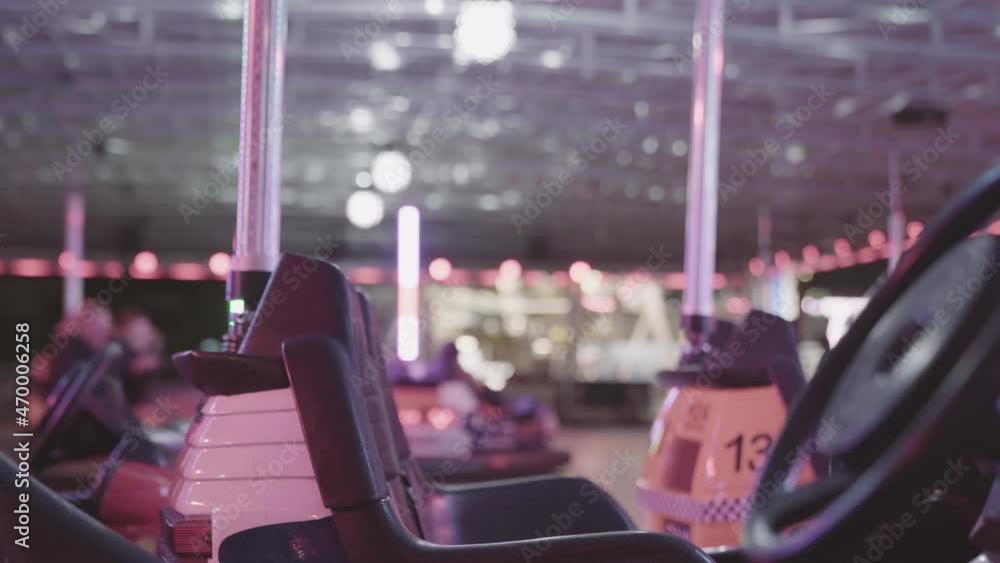 Amusement park backward shot of dumper cars flashing neon light on ...