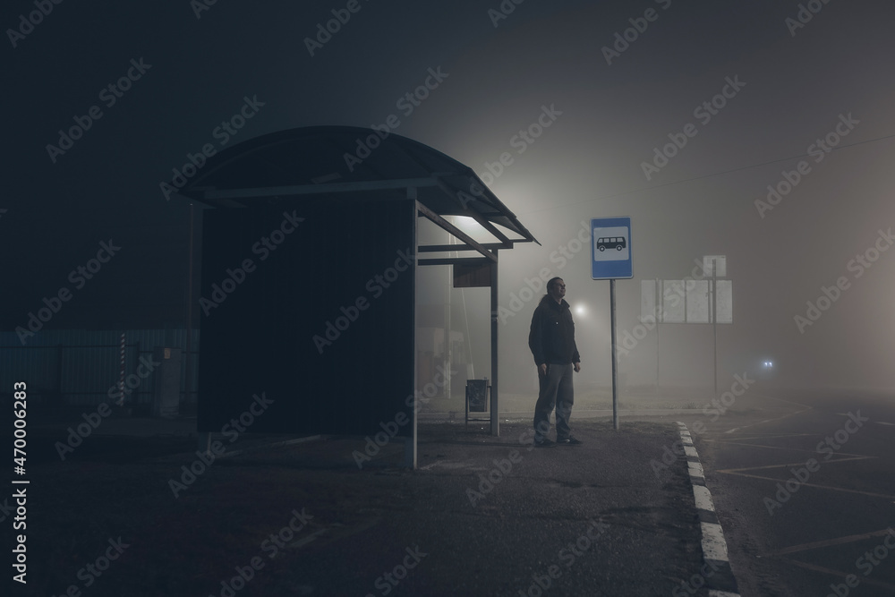 Alone sad man waiting for bus at bus stop Stock Photo | Adobe Stock