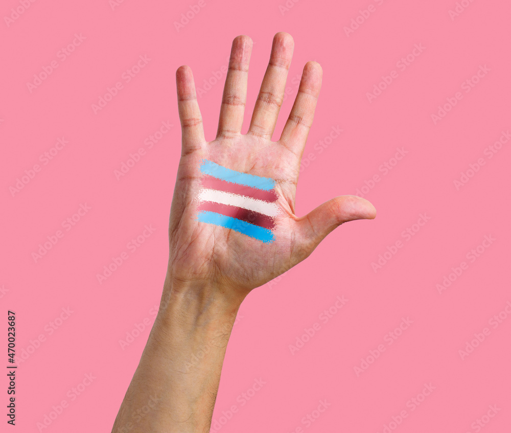 closeup of a transgender flag painted in the palm of the hand of a ...