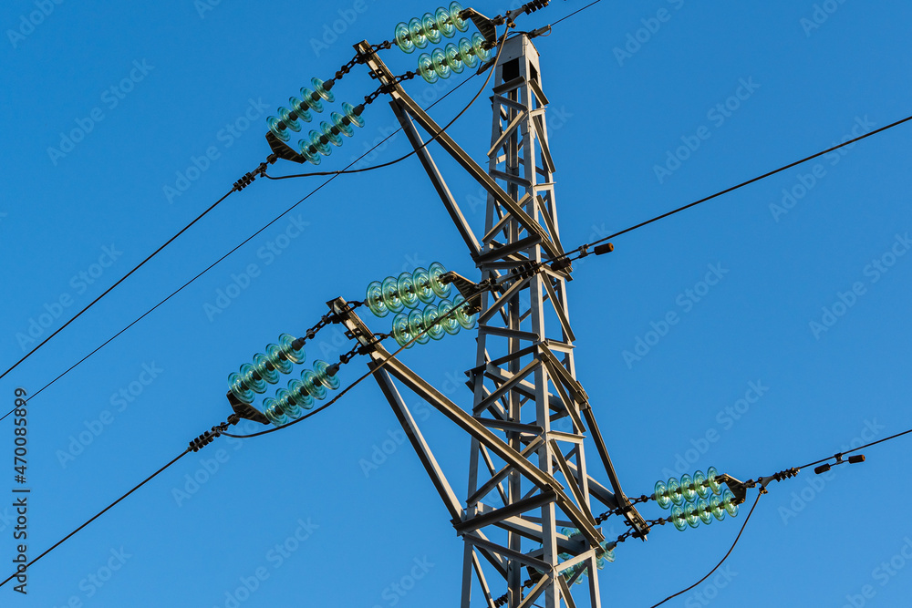 Double-circuit aerial power transmission tower against blue sky. Steel ...